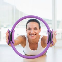 Eine Frau trainiert mit einem Pilates Ring