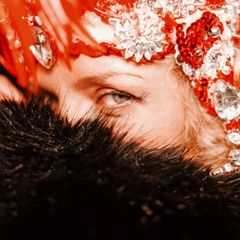 Symbolbild Narzissmus: Eine Frau schaut schelmisch in die Kamera