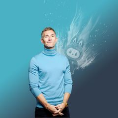 Micky Beisenherz in blauem Oberteil, dahinter ein Stofftier in Flammen