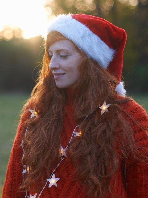 Eine junge mit einer Nikolaus-Mütze Frau blickt traurig