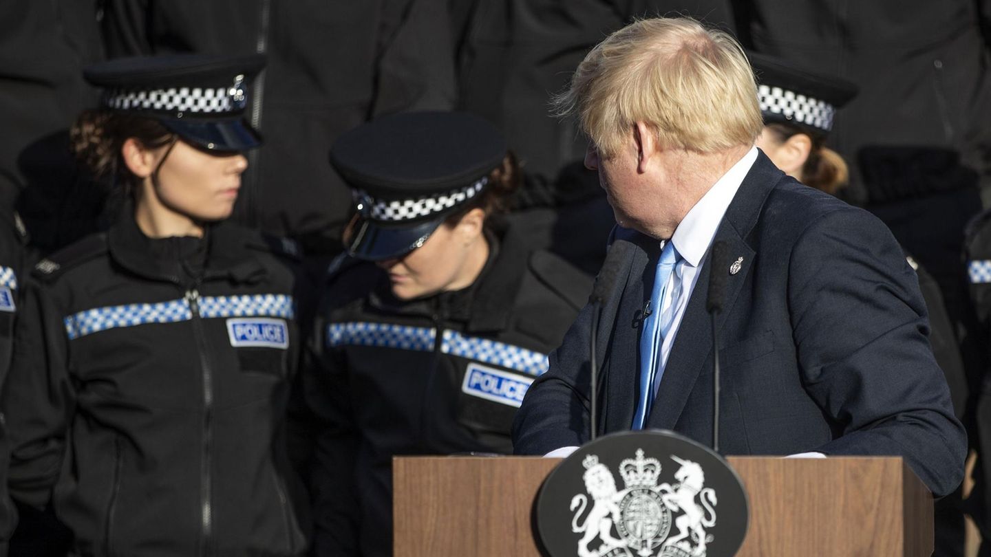 Boris Johnson redet ungerührt weiter, nachdem eine Frau hinter ihm zu ...